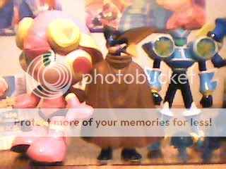 My adorable Roll.EXE plushie, leaning on Forte-sama... I doubt he likes ...